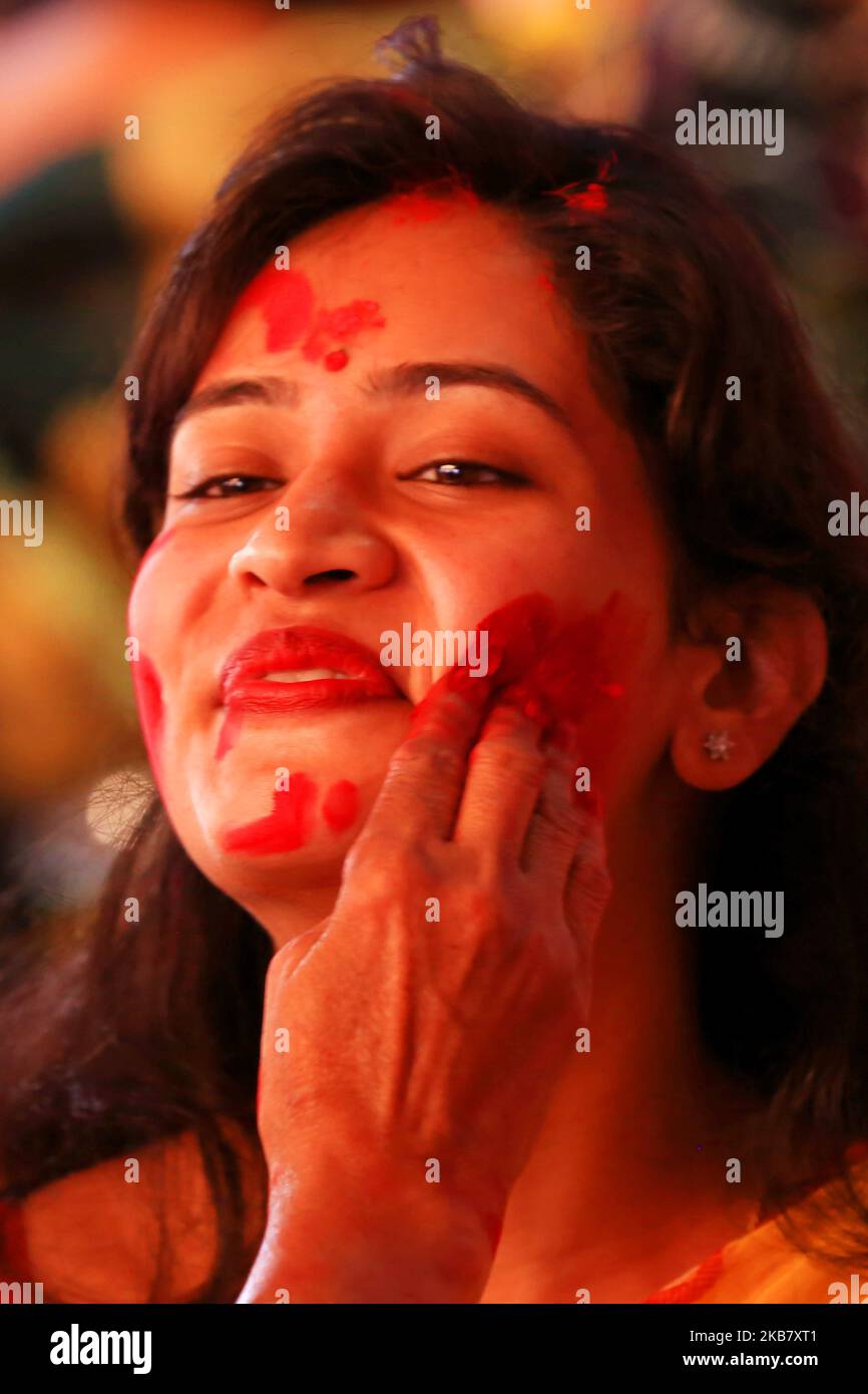 A woman reacts as Sindur or vermillion powder, is applied to her face ...