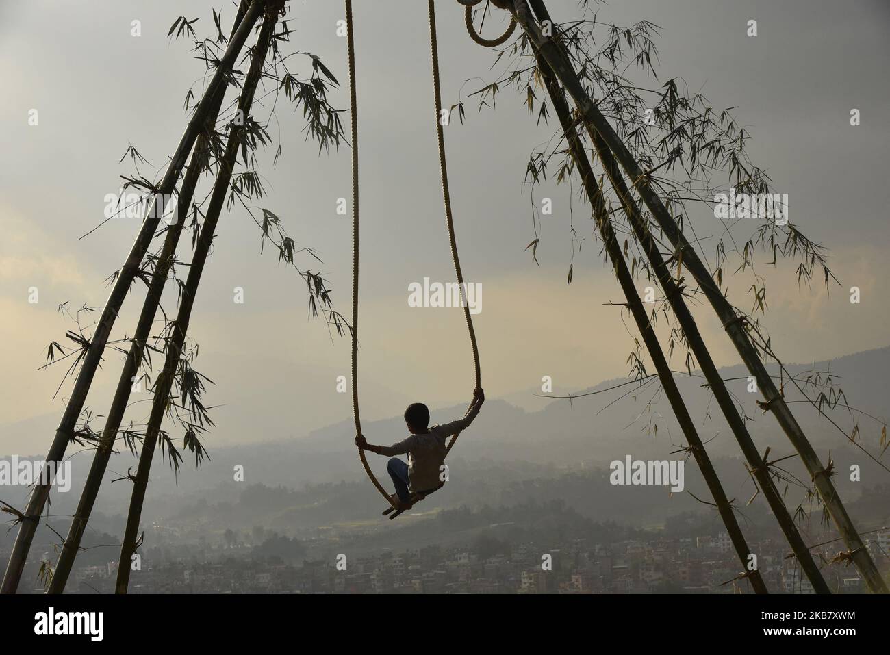 A Nepalese Little Kid girl play on a traditional bamboo ping or swing ...