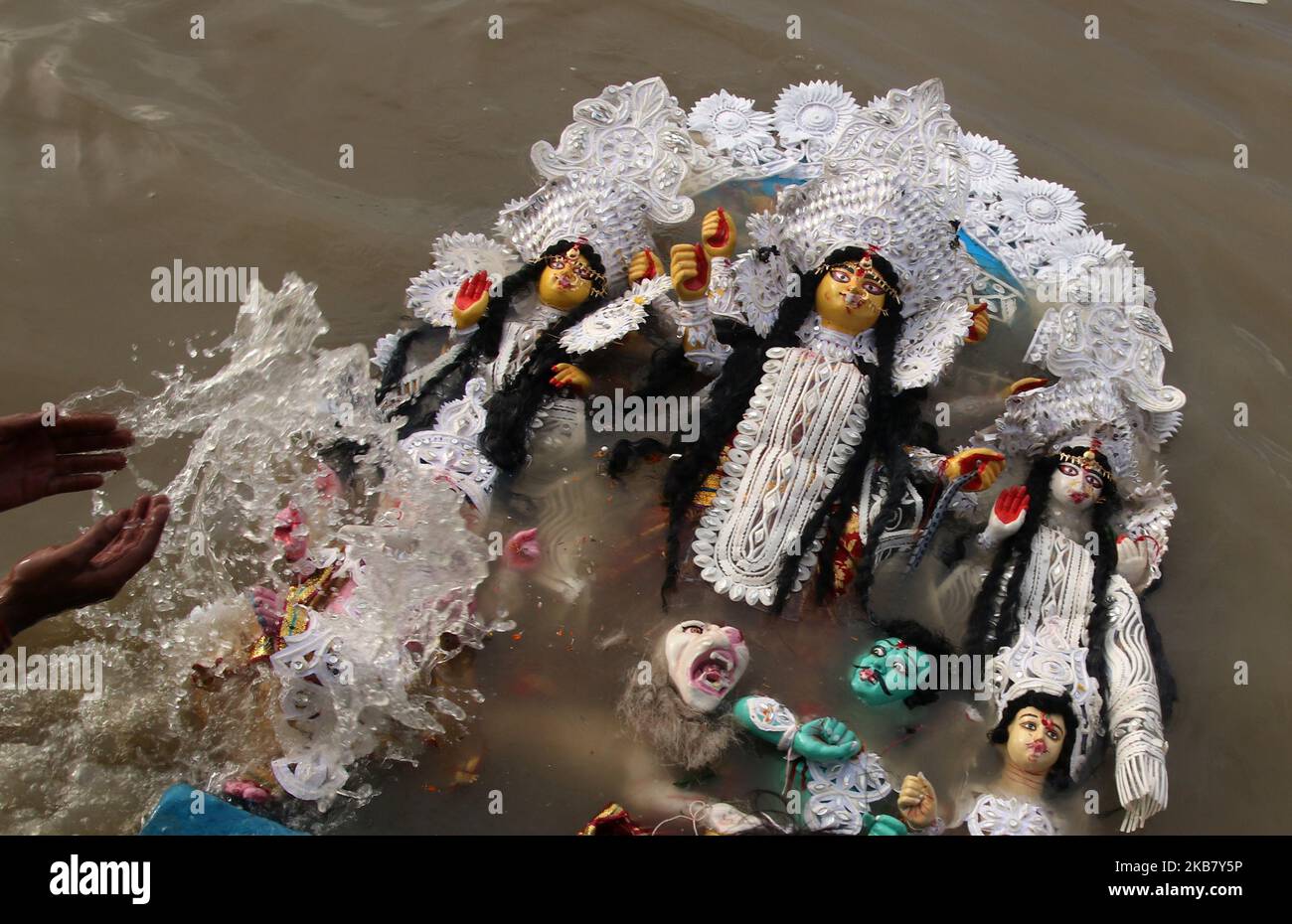 Hindu goddess Durga into the Ganges river during the immersion ceremony ...
