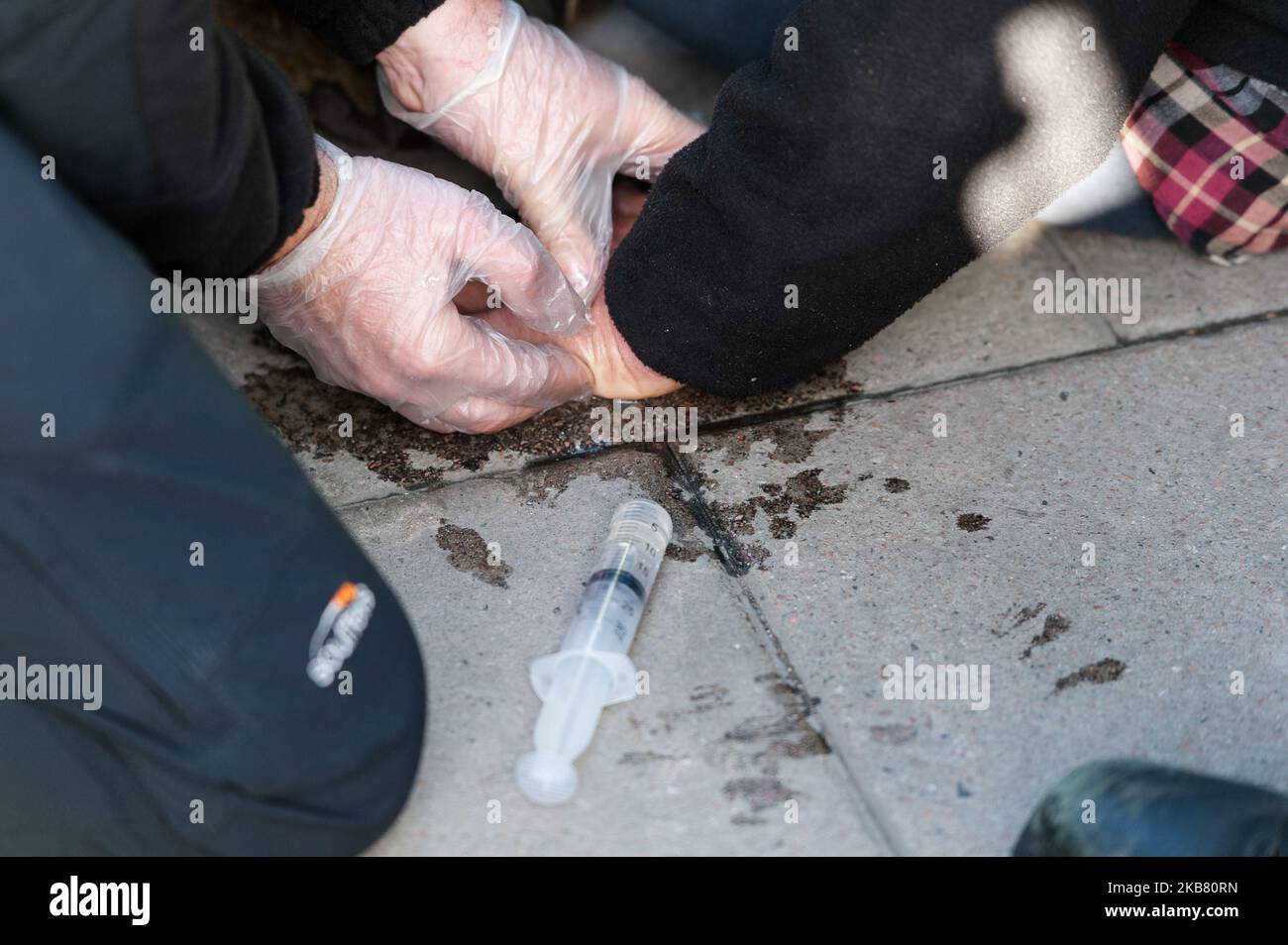 Police officers try to remove a hand of protester who glued himself to ...