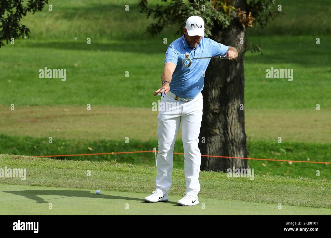 Lee Westwood (ENG) trying to remove a spider's web from his golf club ...