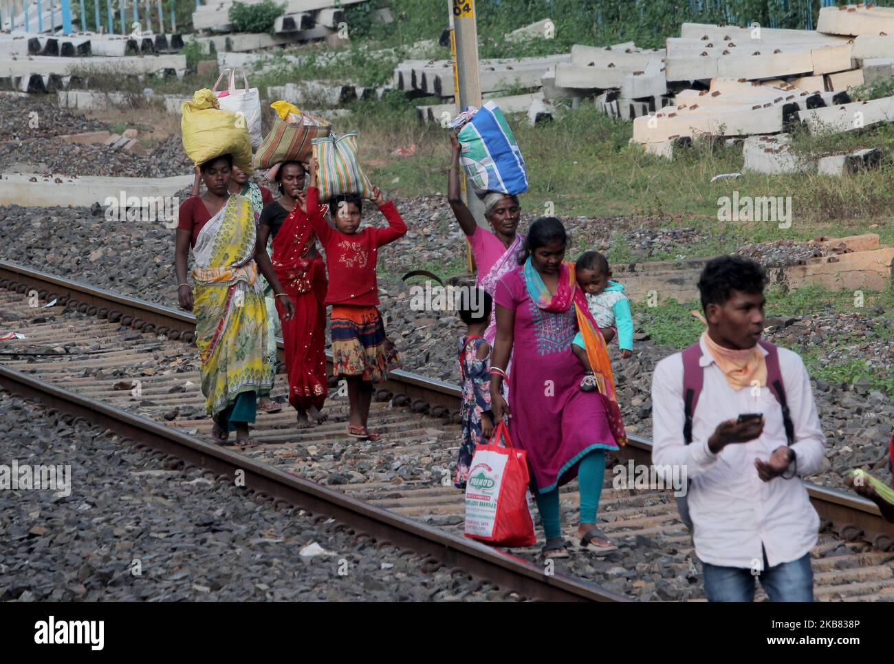 Tribal villagers balanced their luggage atop their head as they walks ...