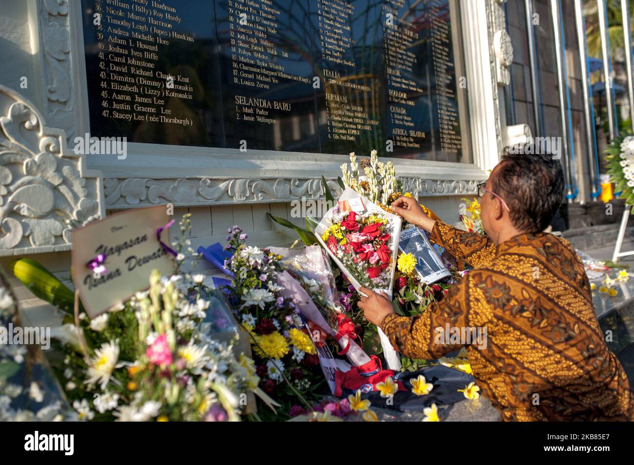 A man lay wreaths around the walls name of victims died on the Bali ...