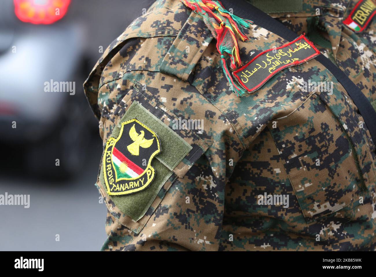 A woman is wearing a battle dress with the Kurdistan Army insignia ...