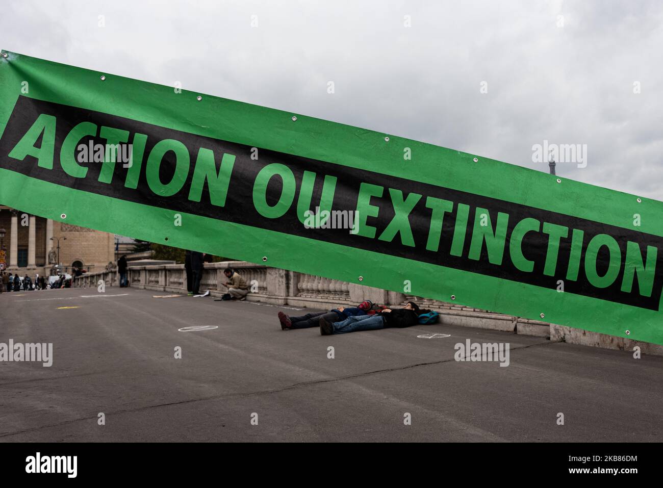 Rebellion Extinction" activists lay on the ground in front of a large ...