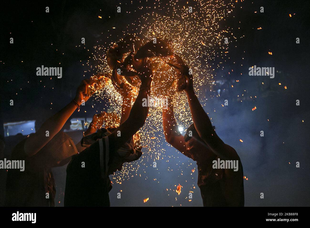 Balinese youngsters banging burnt dried coconut shells on top of their ...