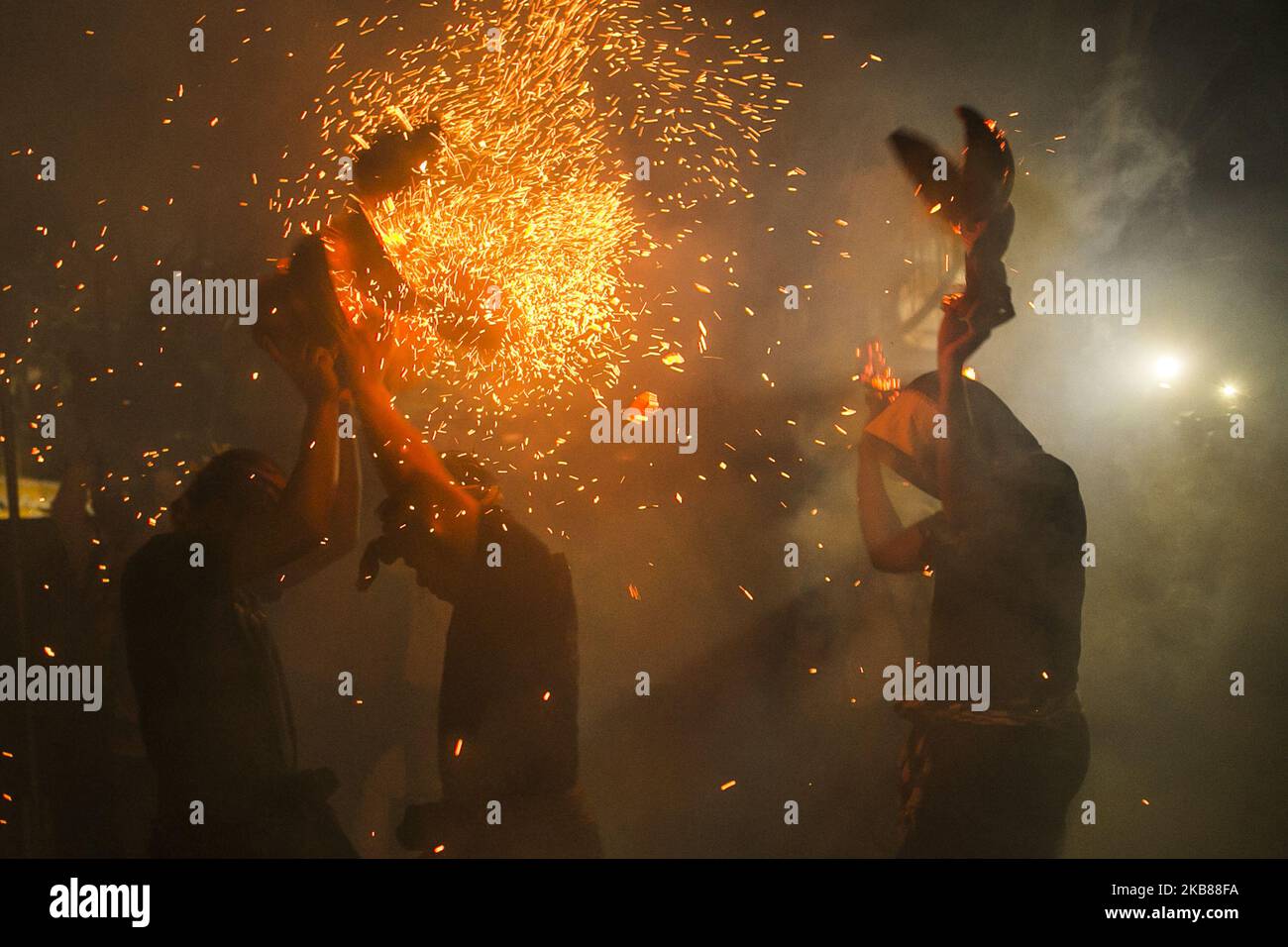 Balinese youngsters banging burnt dried coconut shells on top of their ...
