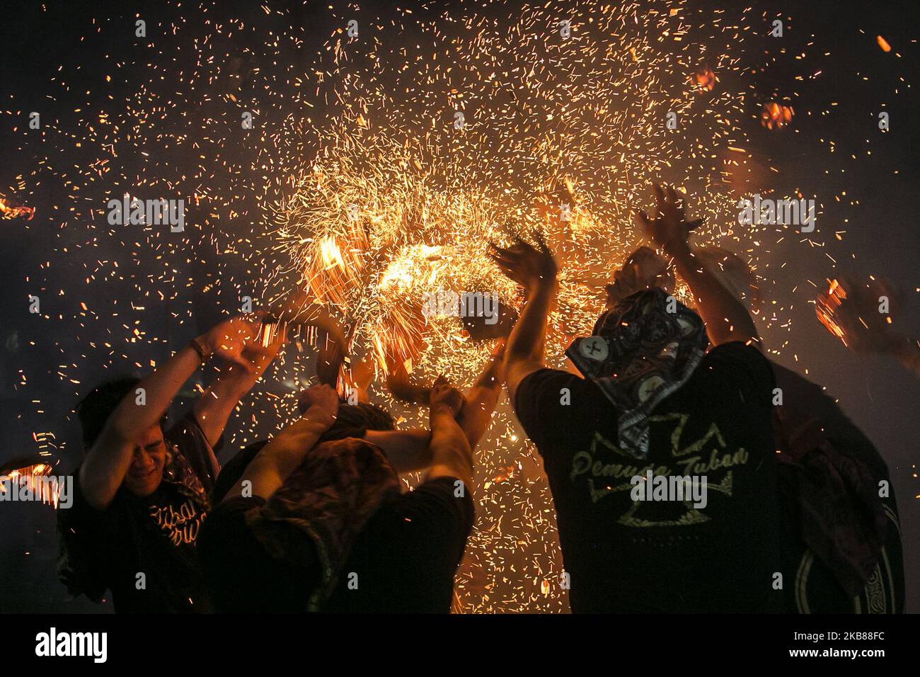 Balinese youngsters banging burnt dried coconut shells on top of their ...