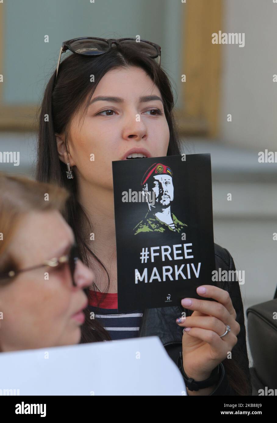 A woman holds a placard with the portrait of Vitaliy Markiv with the ...