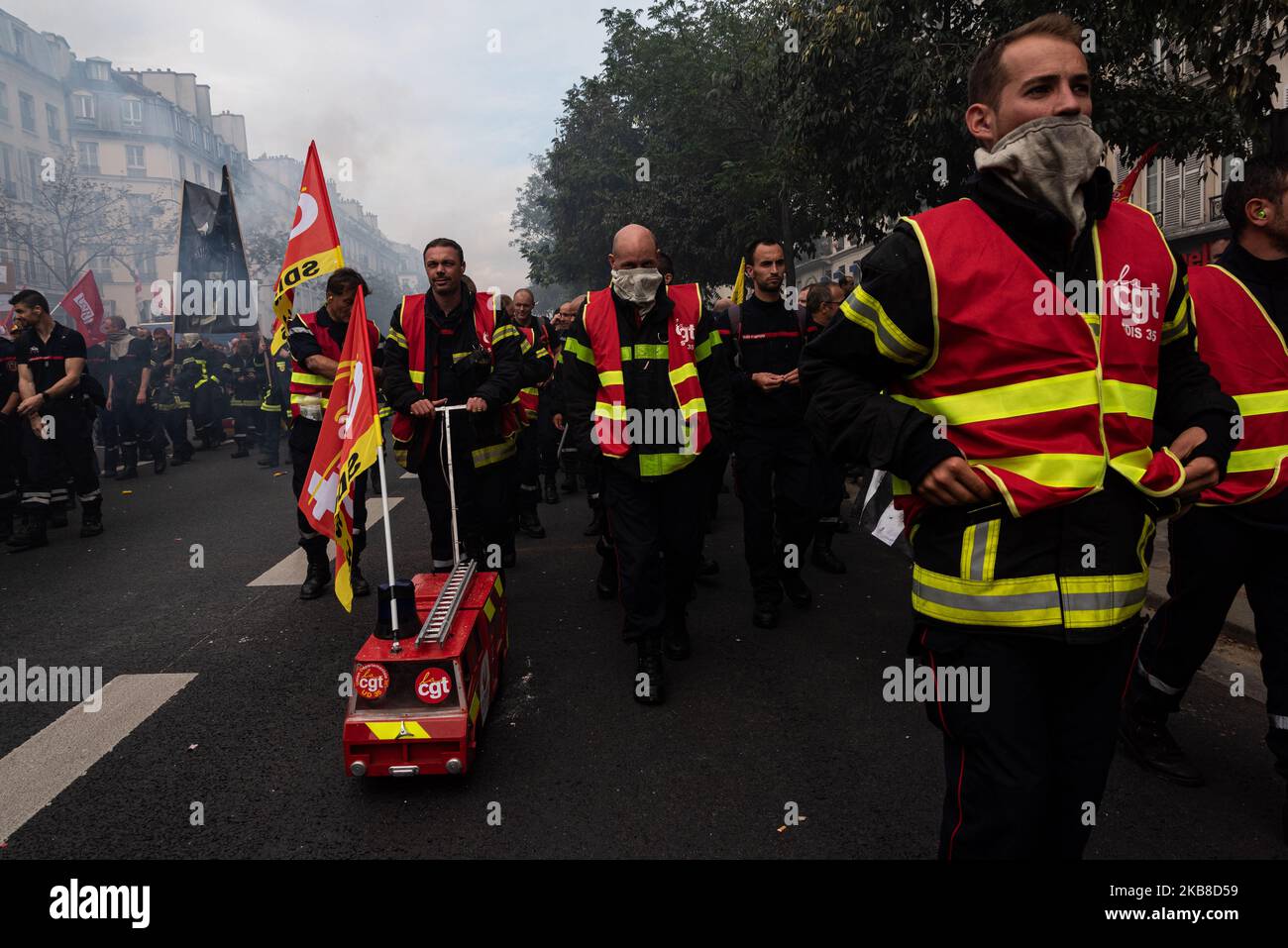 Firefighters are marching in the procession with small carts in the ...
