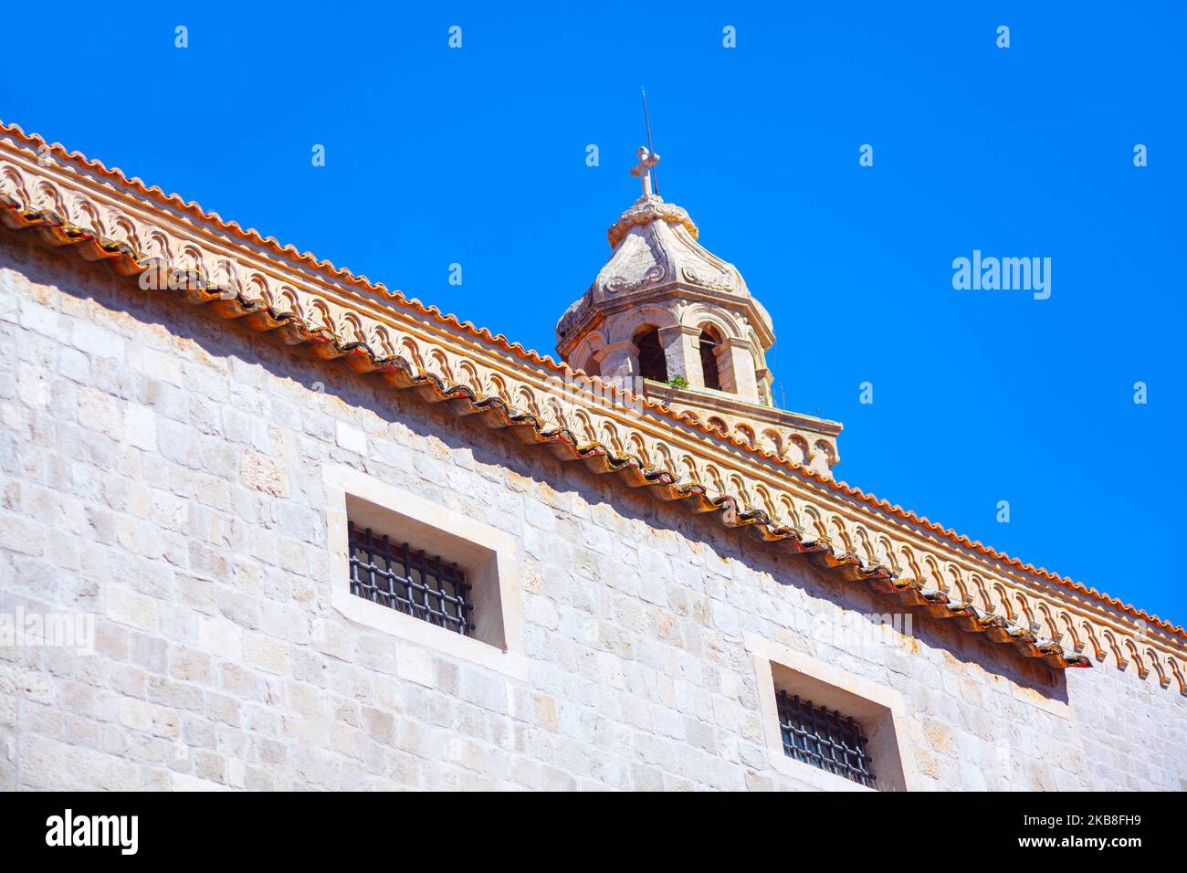 Turret and tiles of the old fort . White wall and windows with grates ...