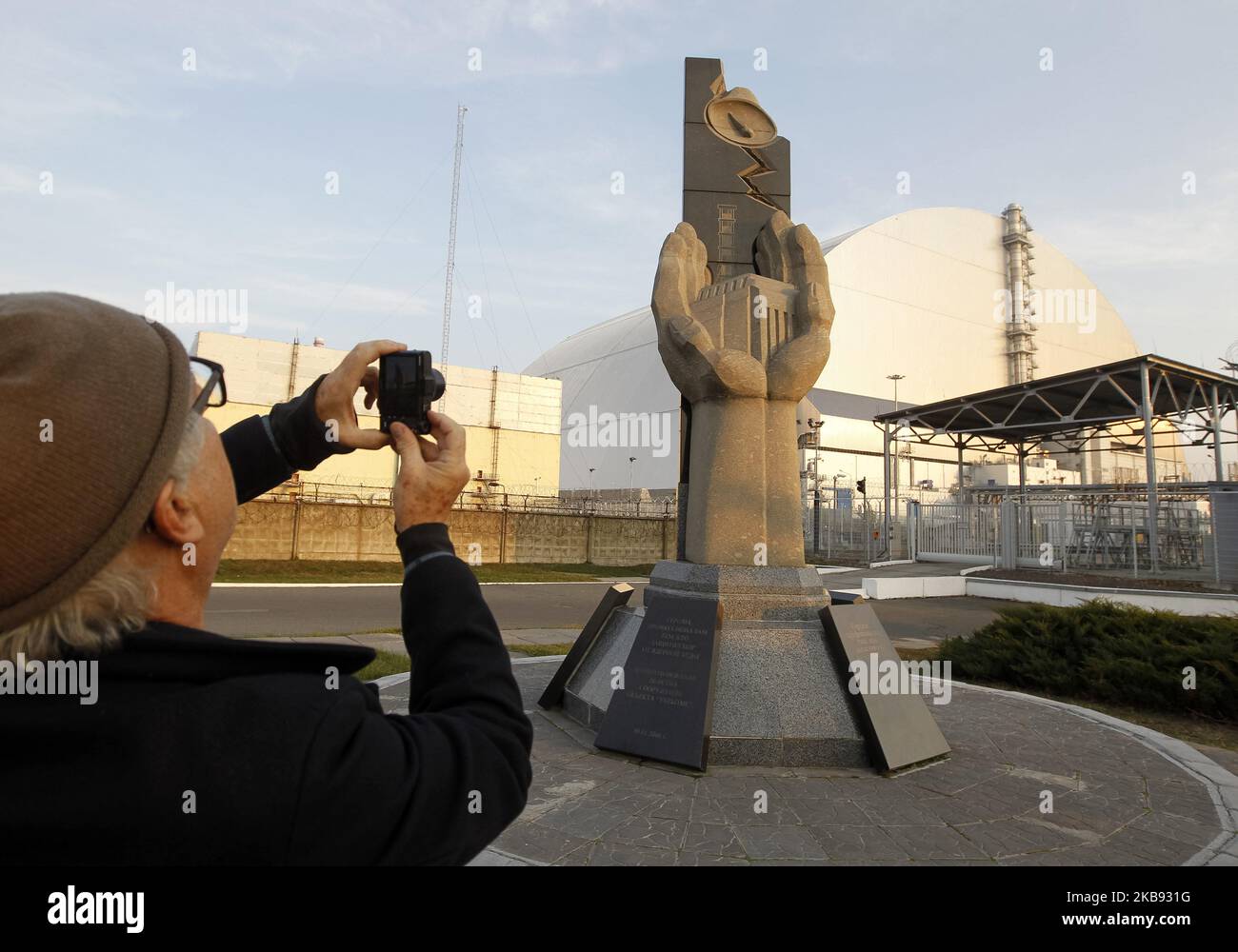 A visitor takes a photo of the Safe Confinement over the 4th block of ...