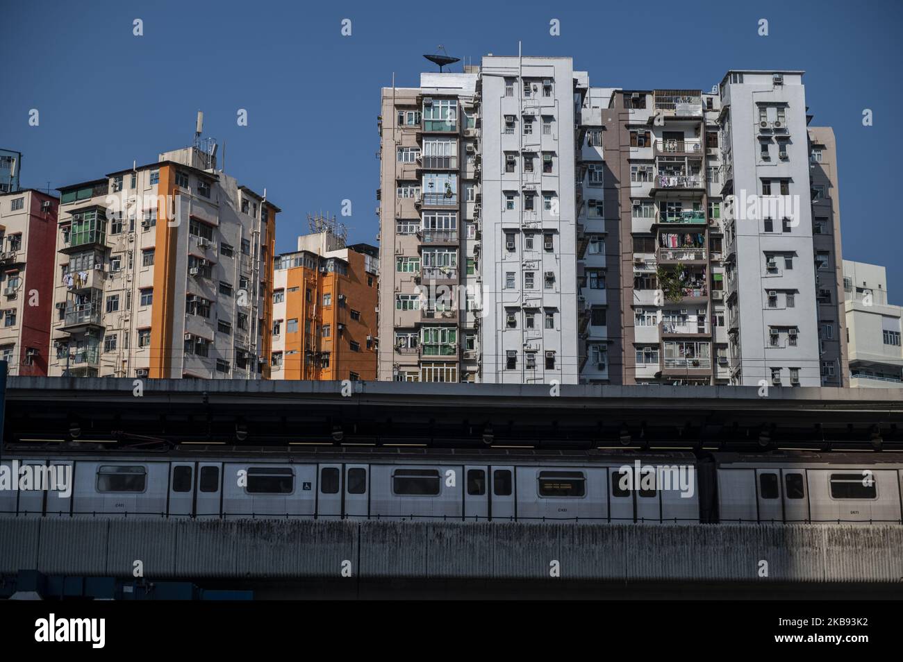 An MTR Train is seen in a station with residential housing surrounding ...