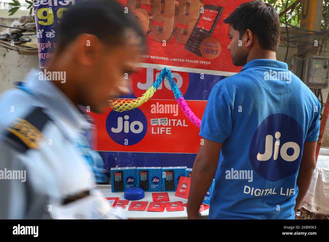 An employee selling new Jio Mobile connections waits for the customers ...