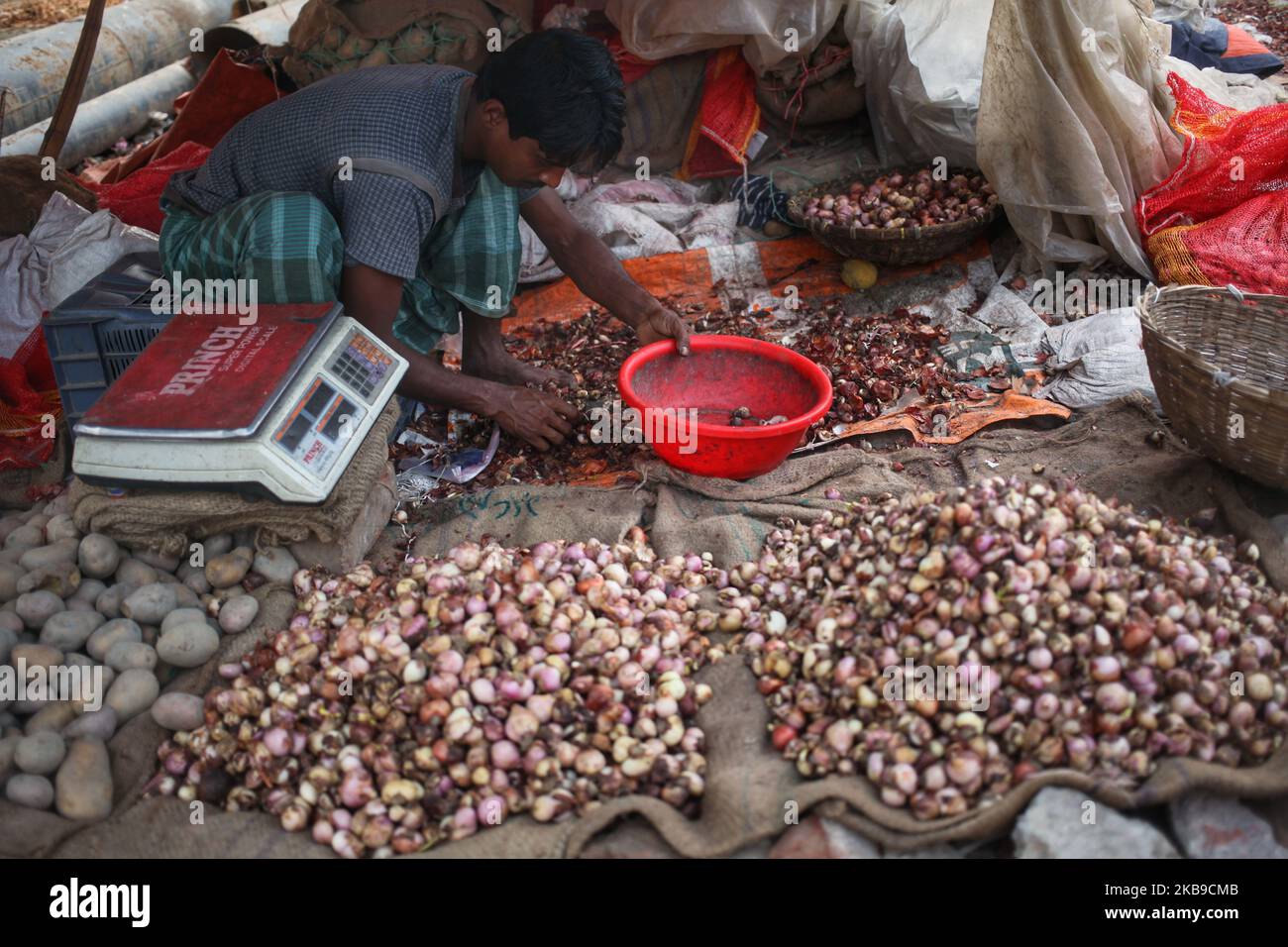 Vendor seen preparing semi-rotten onion to sell in a market of a low ...