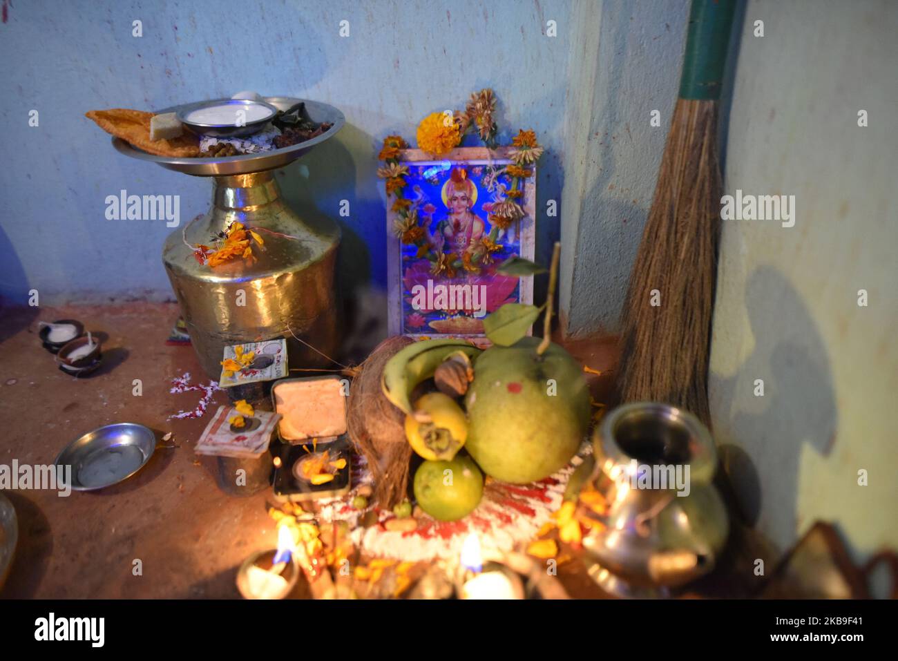 A Nepalese devotee offering ritual prayer towards a poster of Laxmi ...