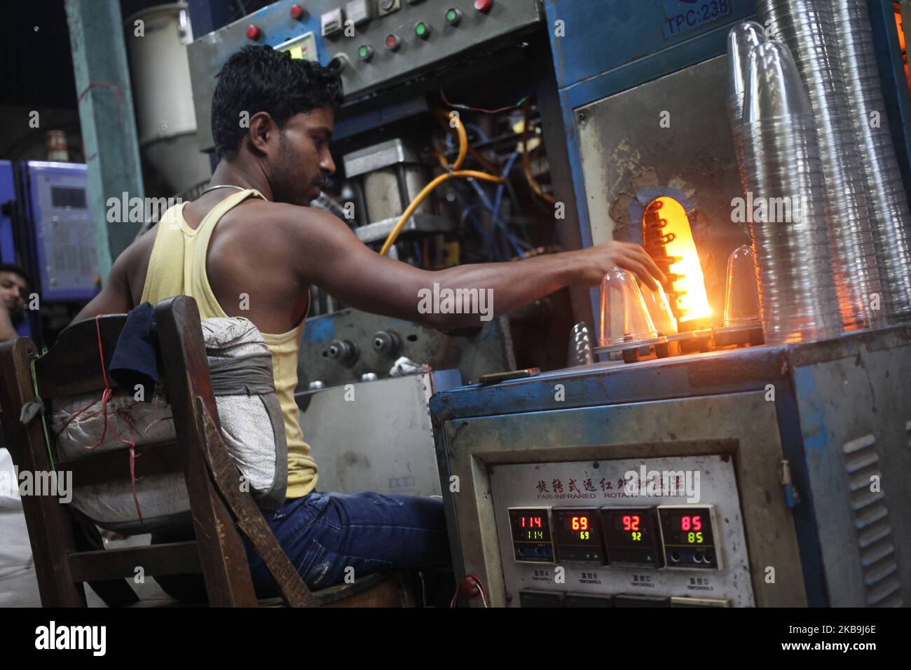 A worker makes plastic jar in a factory in Dhaka, Bangladesh on 30 ...