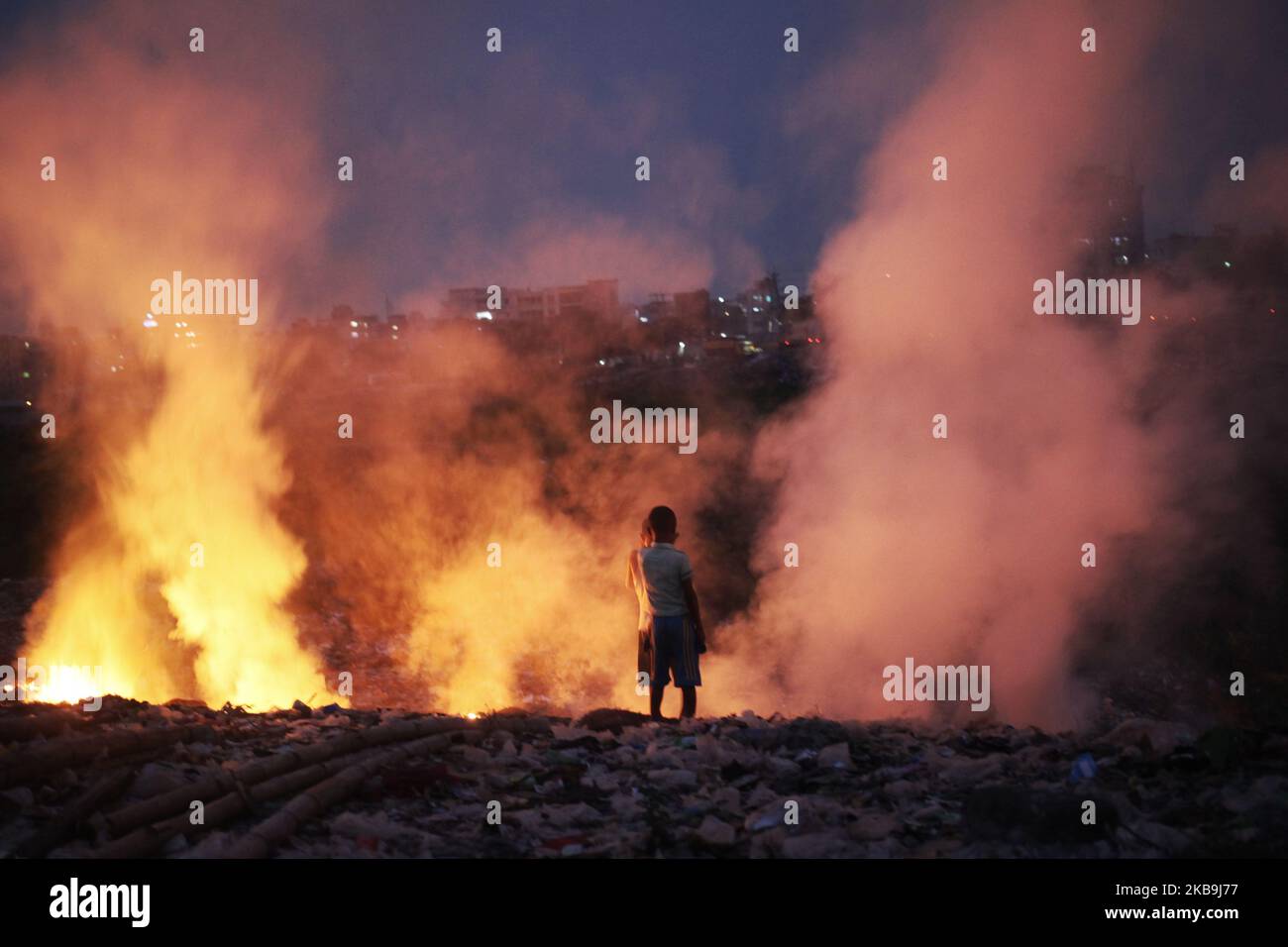 Children seen working as toxic garbage are buring in a dumping area ...