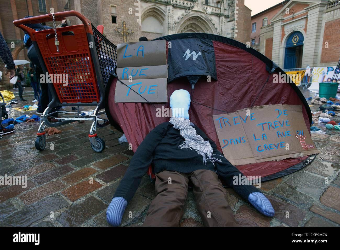 A rag doll in front of a tent whith placards reading 'Street Kills' and ...