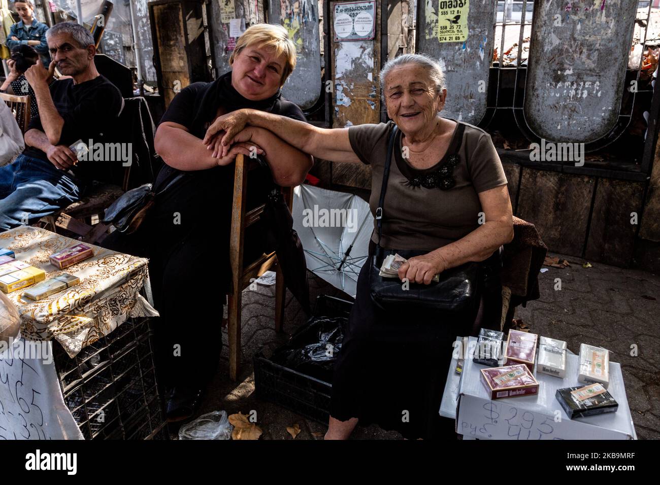 Women sell cigarettes on their small stand on the town's open air ...