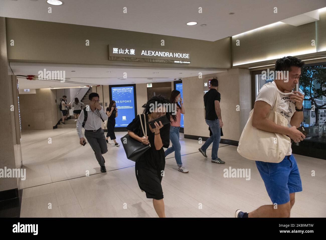 People are seen covering their mouths while running throw a shopping ...