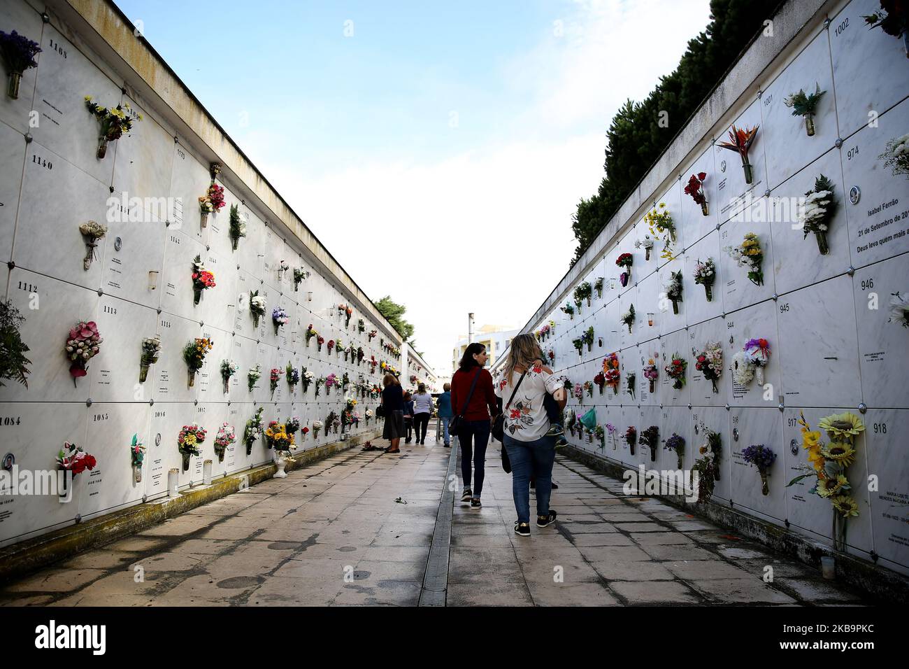 People walk past graves at a cemetery during the annual observance of ...