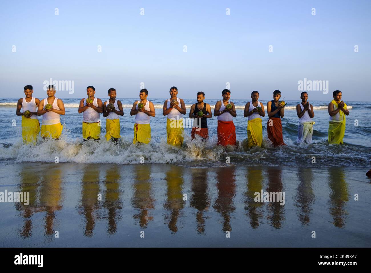 A group of men is worshipping the Sun god during the Chhath puja at ...