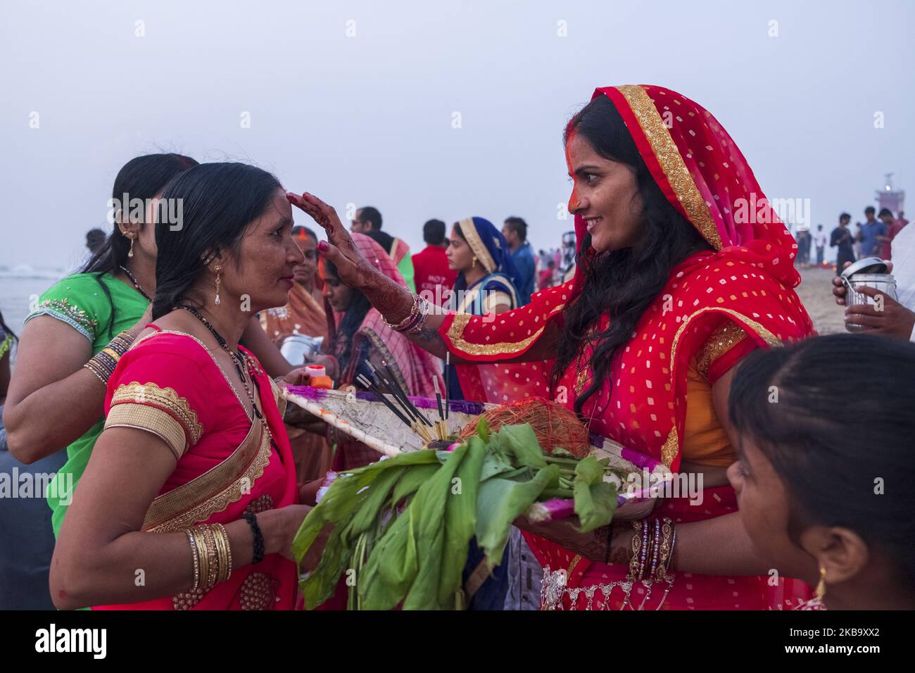 Women dressed up in their traditional attire, exchange 'kumkum' a red ...