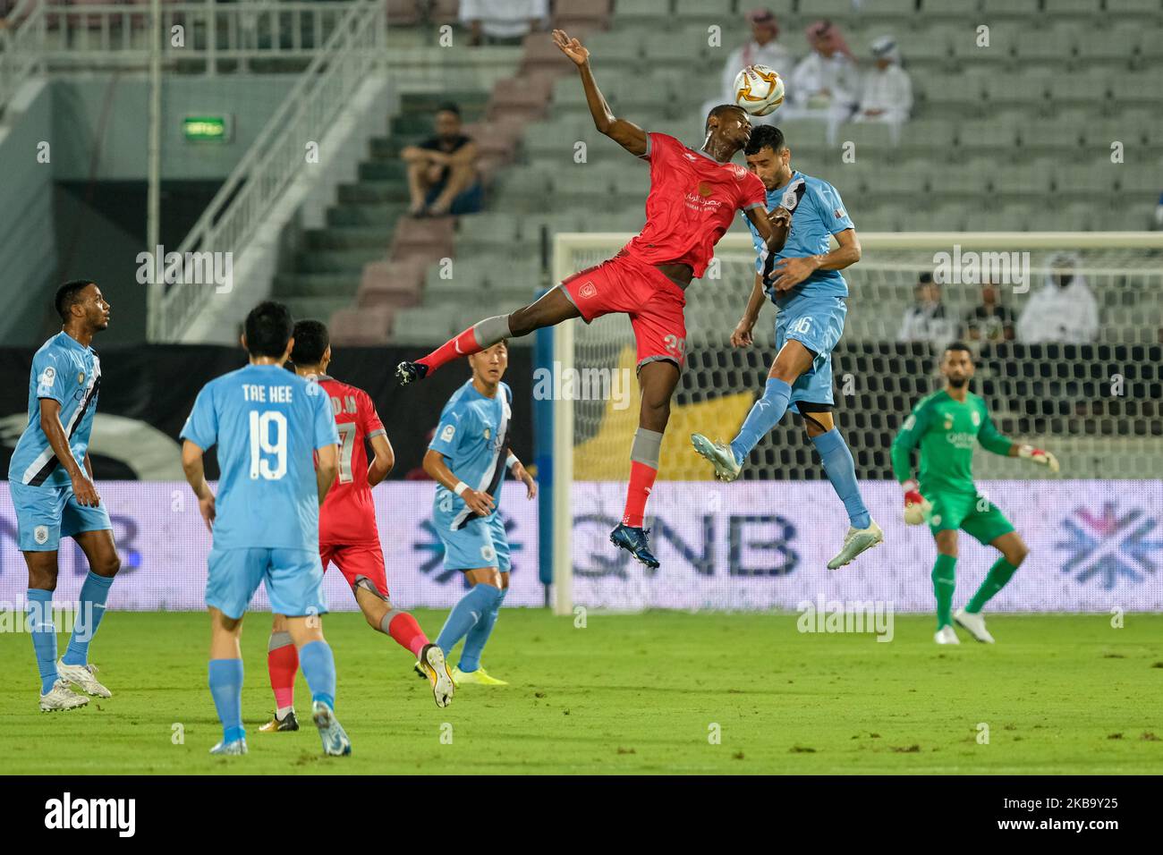 Al Duhail's Mohammed Muntari wins a header over Al Sadd's Boualem ...