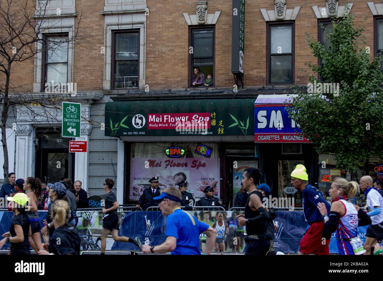 Spectators watch from their window at the New York City Marathon Sunday ...