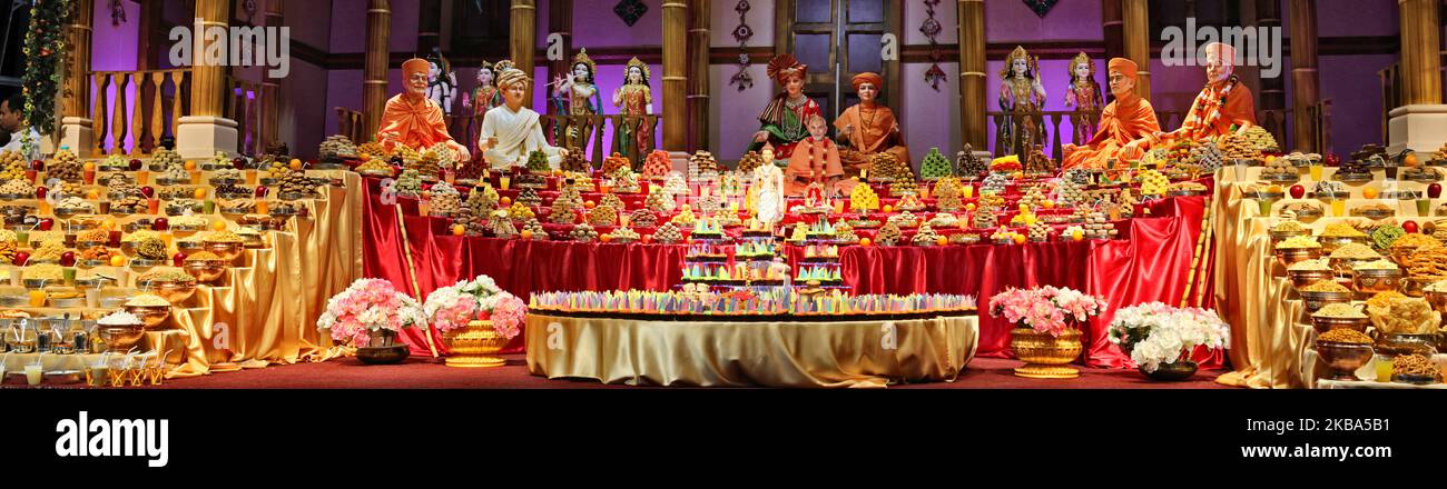 Mountains of sweets and vegetarian snacks are displayed in front of the ...