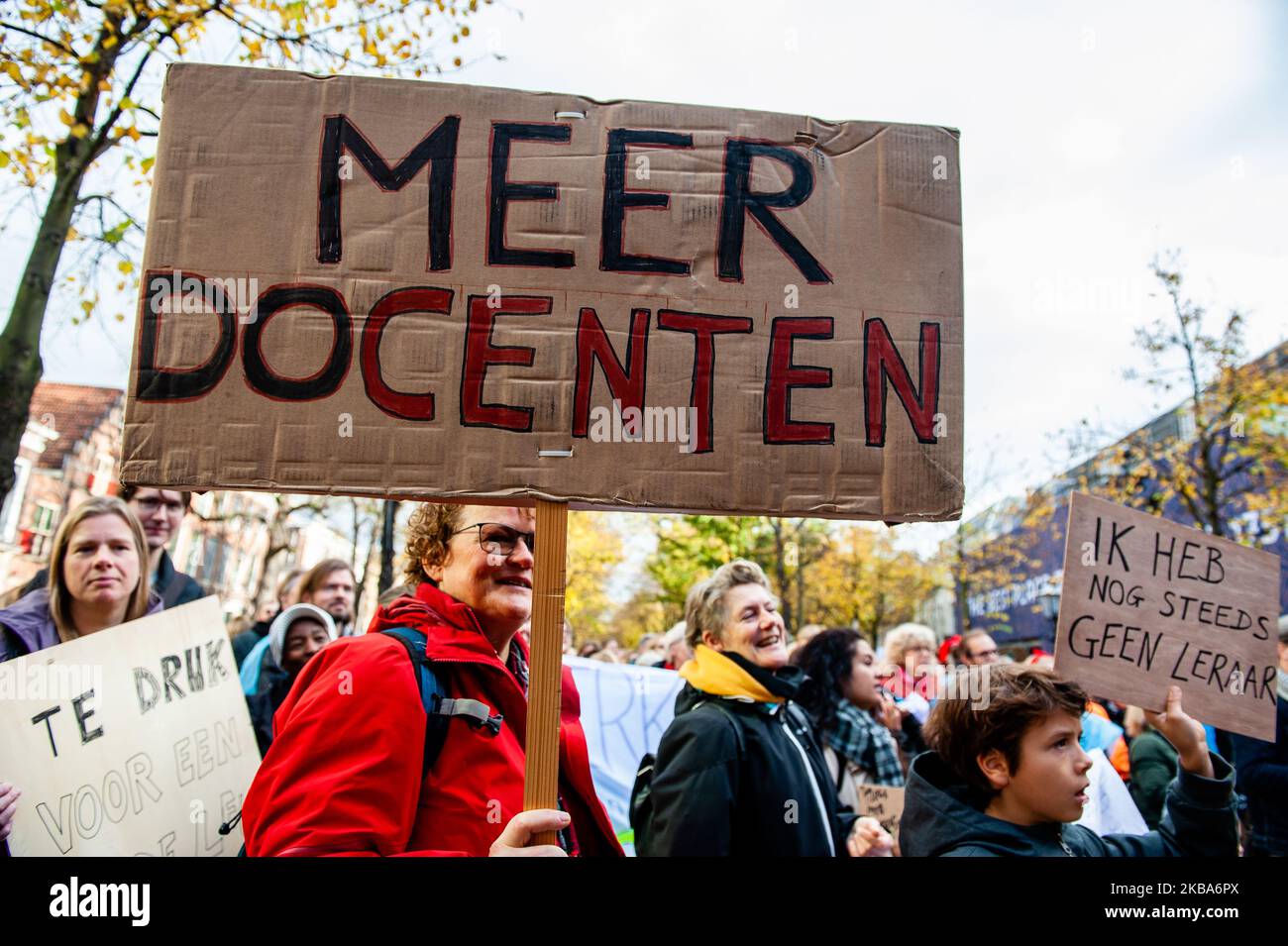 A woman is seen holding a big placard that means more teachers, during ...