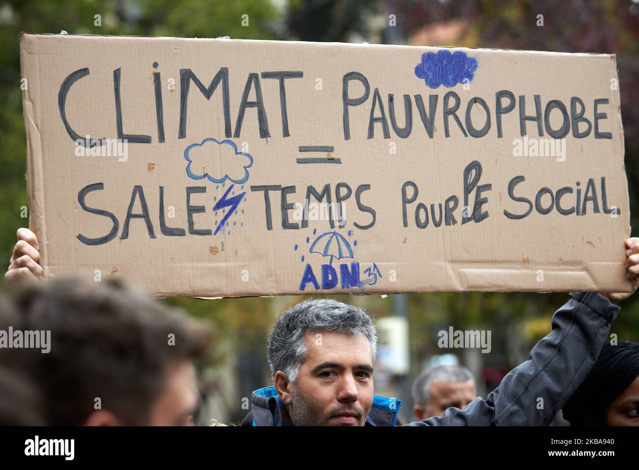 A social worker holds a placard reading 'A poorphobic climate equal bad ...