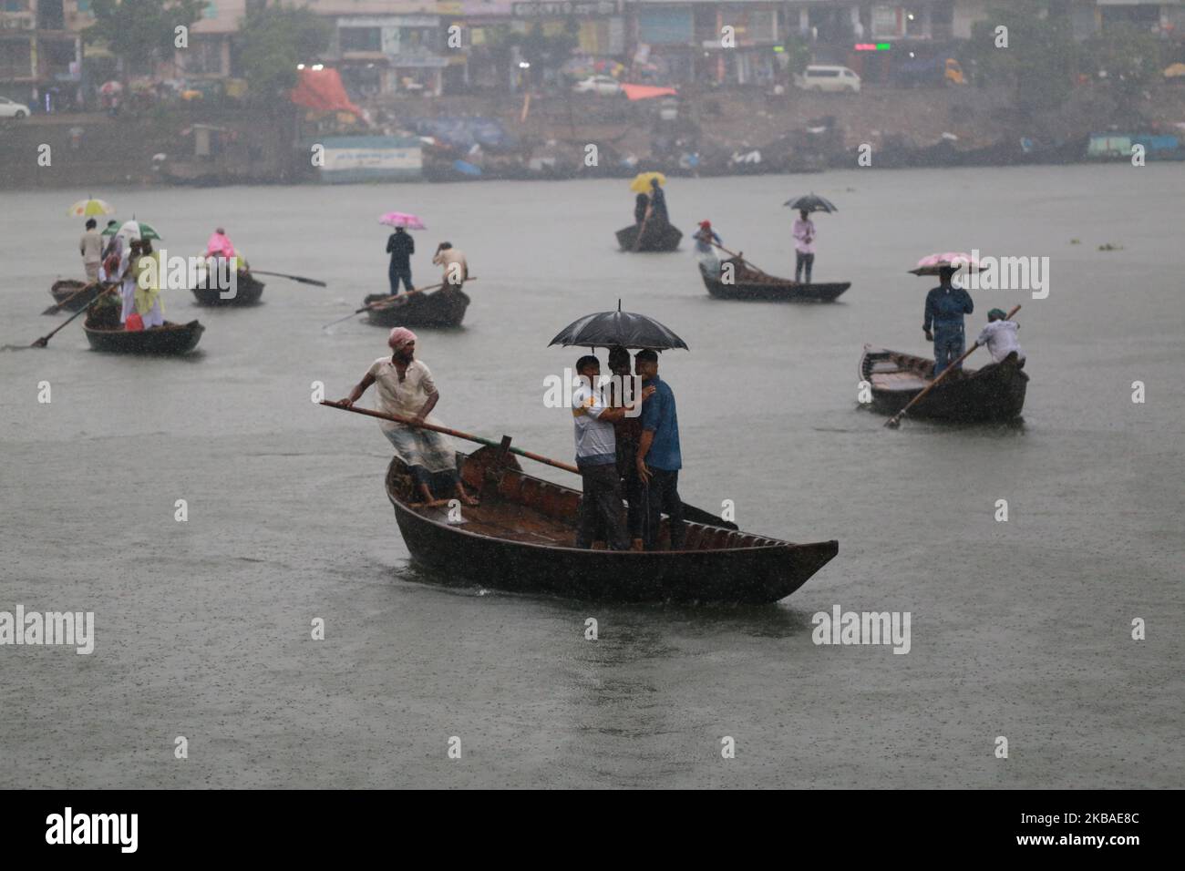People crossing the Buriganga River by boat during the rainfall as ...