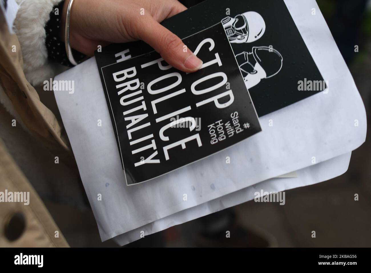 An activist holds 'Stop Police Brutality' leaflets during a protest in ...