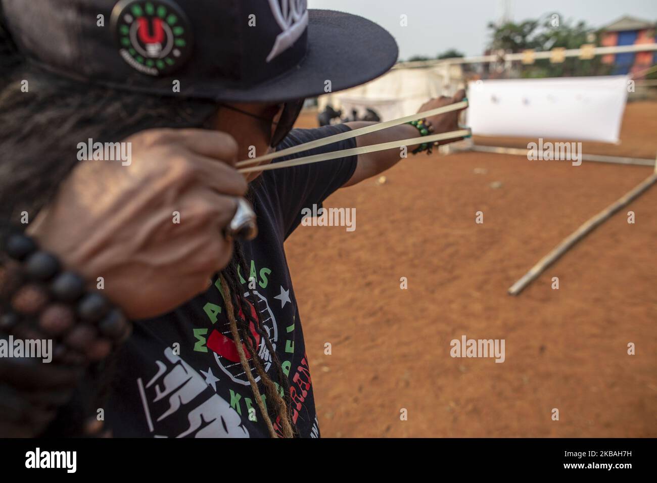 A participant aim his slingshot to shoot the target during the event in ...