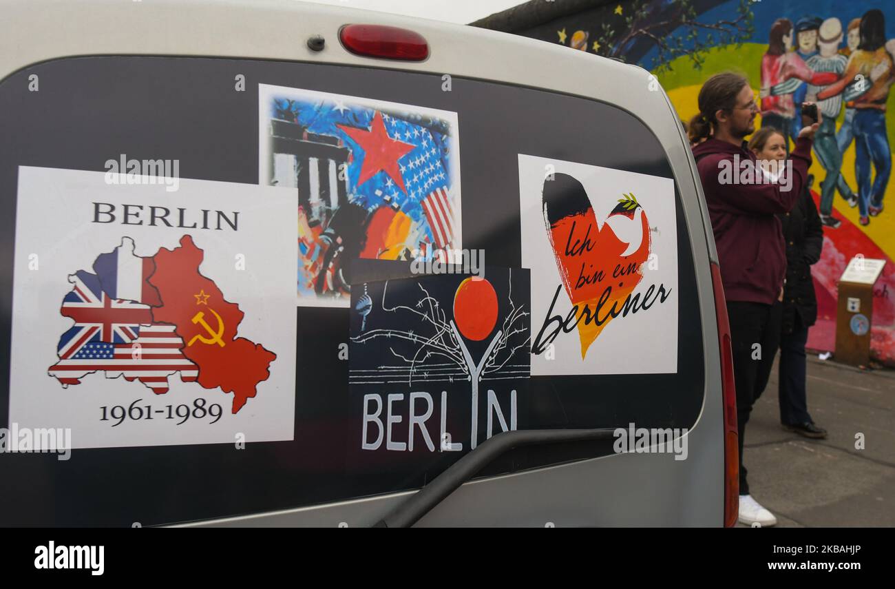 A car with Berlin Wall related stickers see next to a still-standing ...