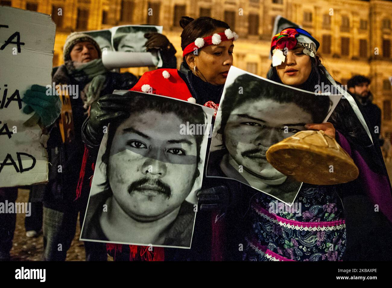 Two women wearing some indigenous clothes is holding a photo of Camilo ...