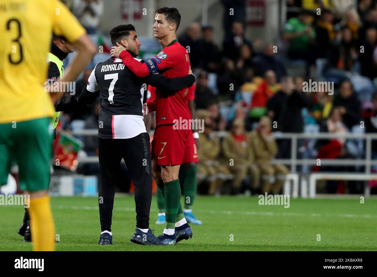 Portugal's forward Cristiano Ronaldo (R ) hugs a fan who invaded the ...