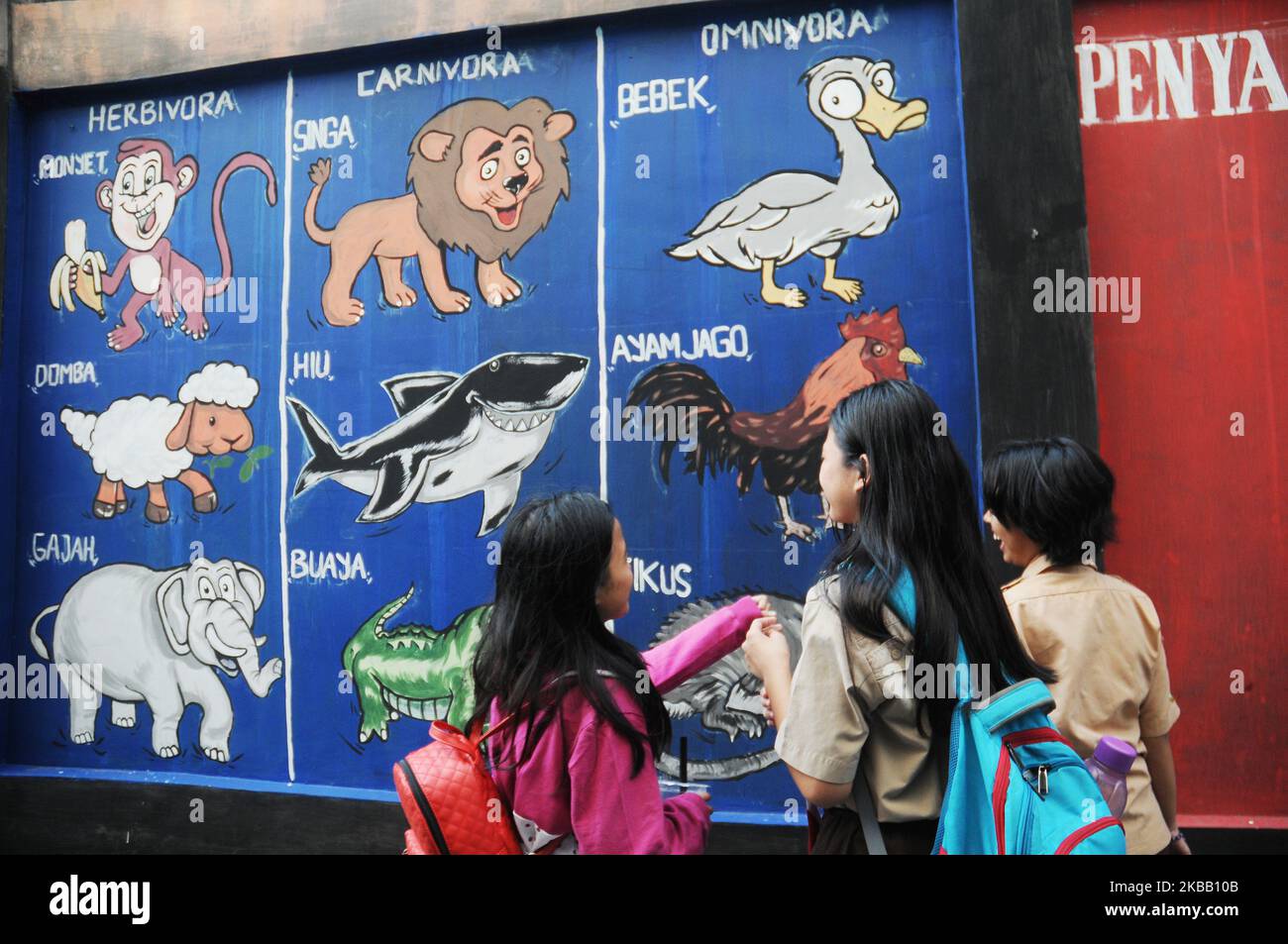 Children with Parents see education Graffiti themed walls in a narrow ...