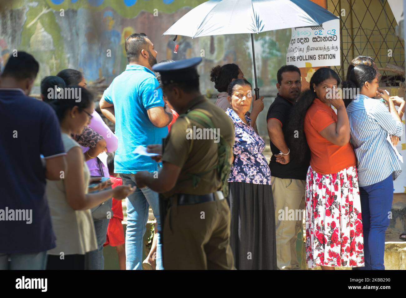 Voters queue up the cast their ballots at a polling station during Sri ...