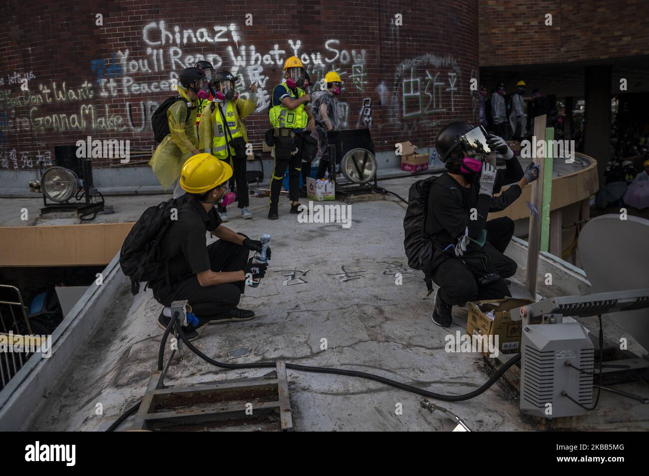 Protesters are seen standing guard on top of a footbridge inside ...