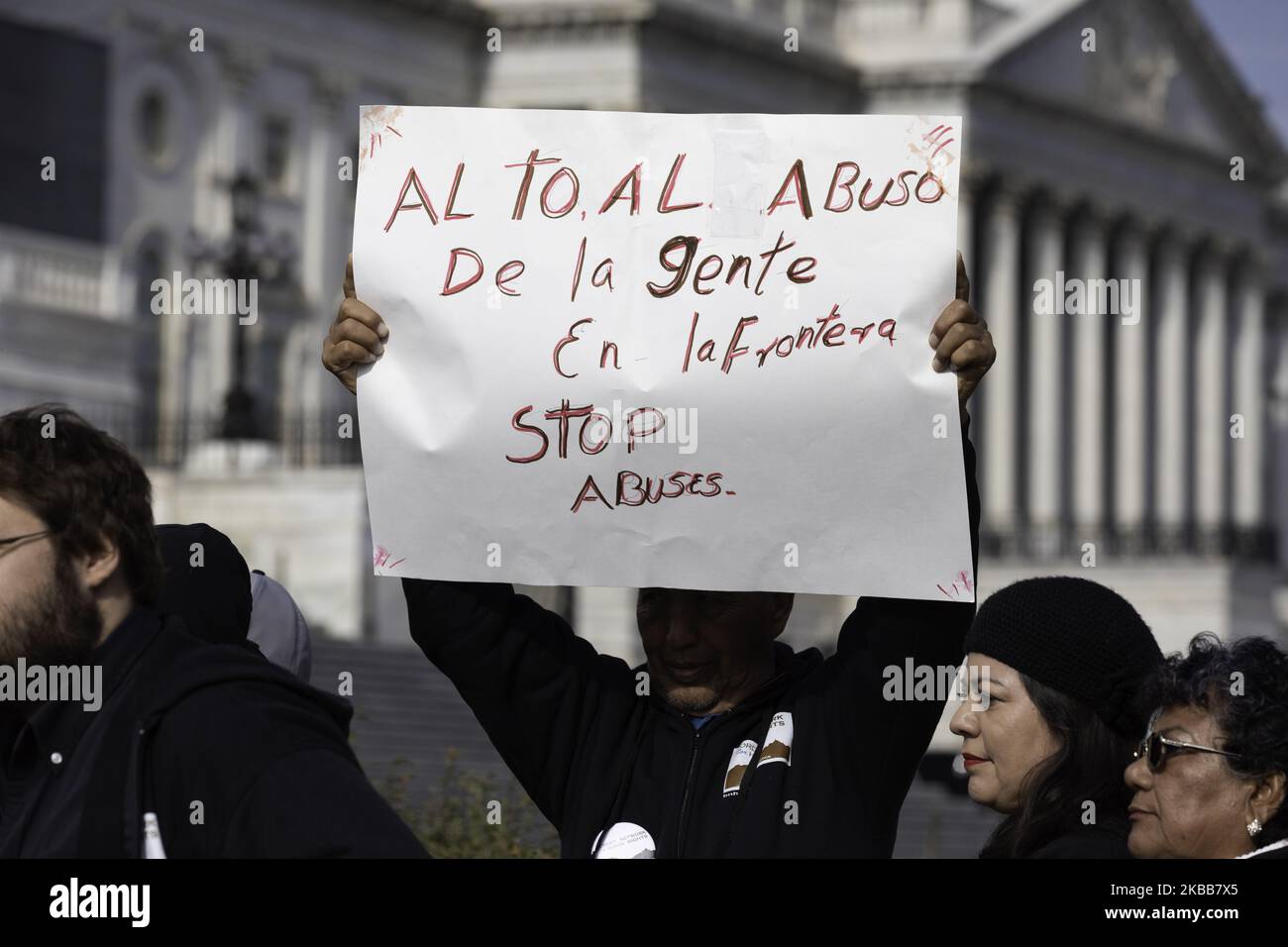 A Border Network for Human Rights (BNHR) member holds a sign during a ...