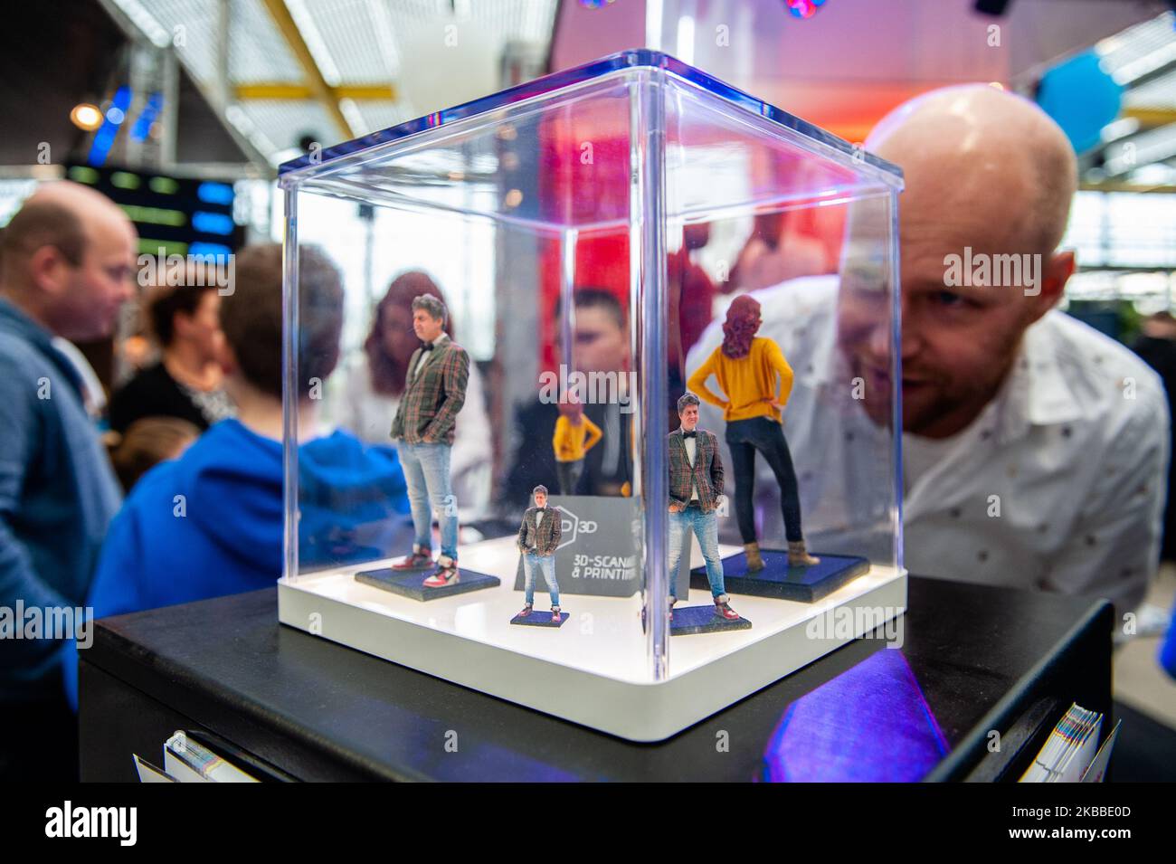 A man is looking a 3D mini people during the Bright Day Festival in ...