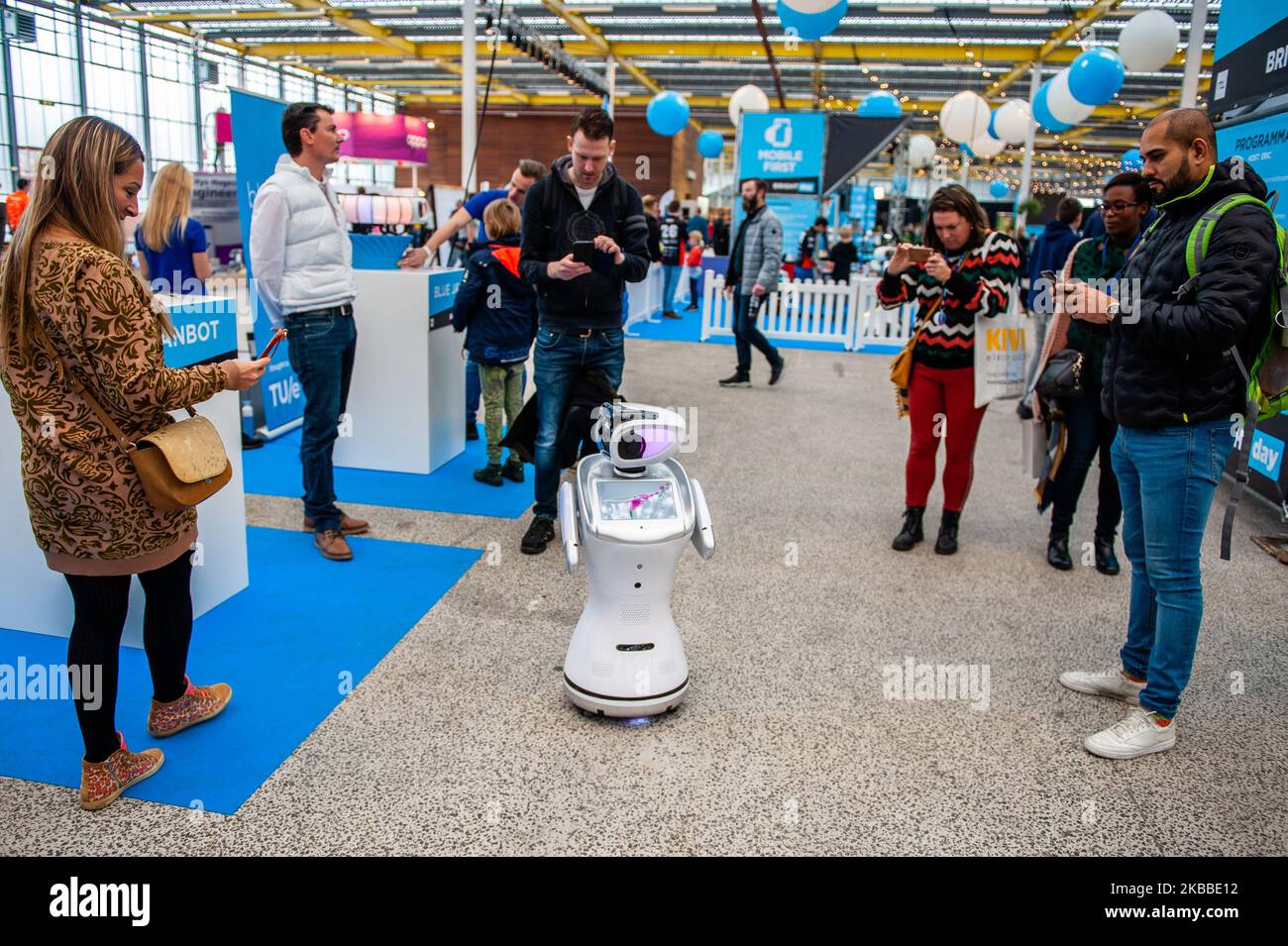 A robot is playing music and dancing surrounded by some audience ...