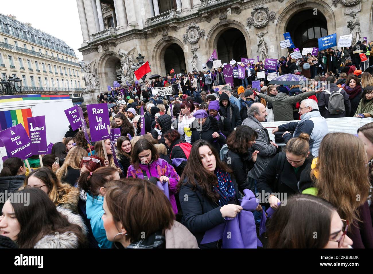 Women hold purple flags and signs during a protest to condemn violence ...