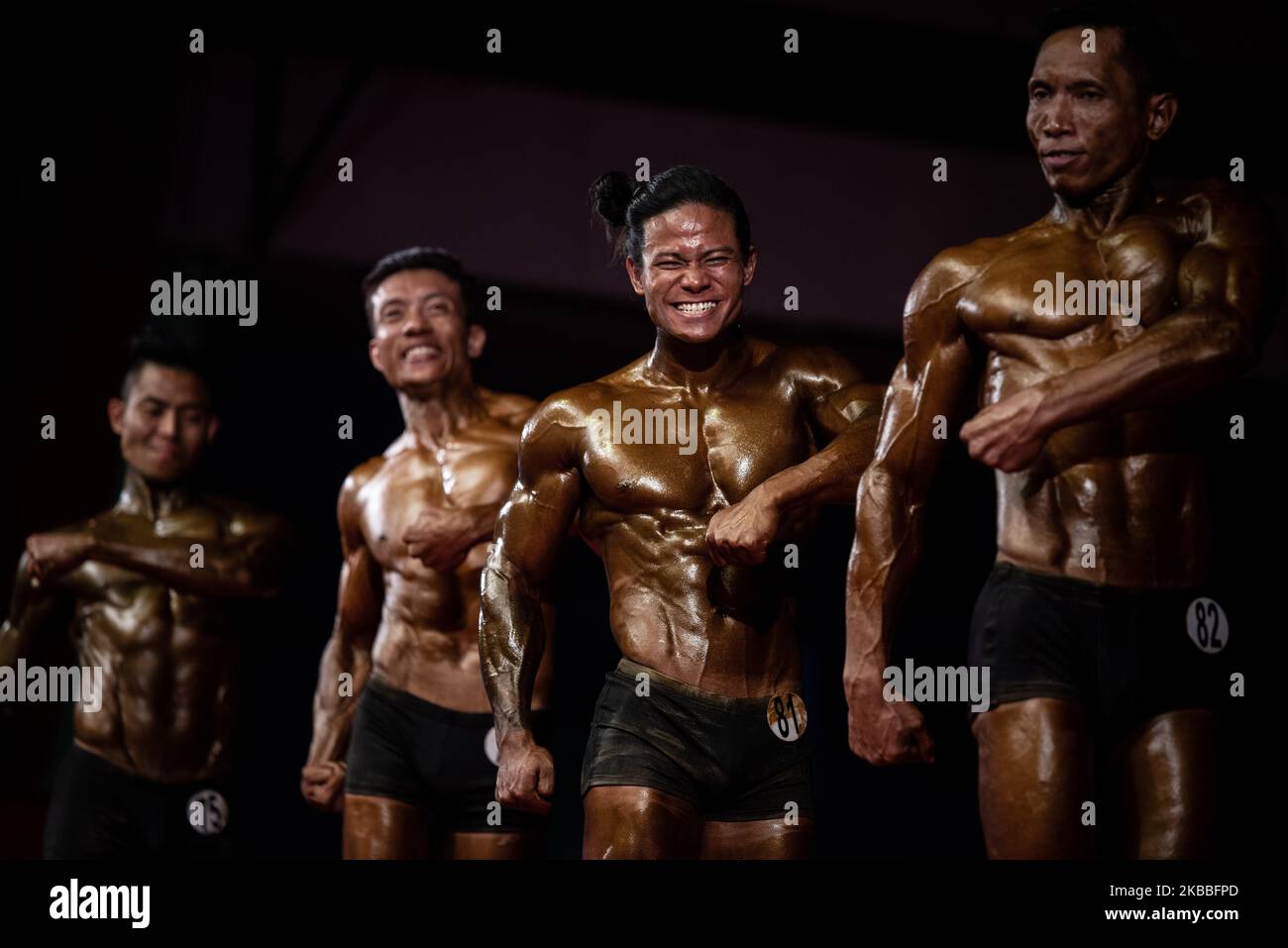 Male bodybuilding athletes pose on stage during the 46th State and ...