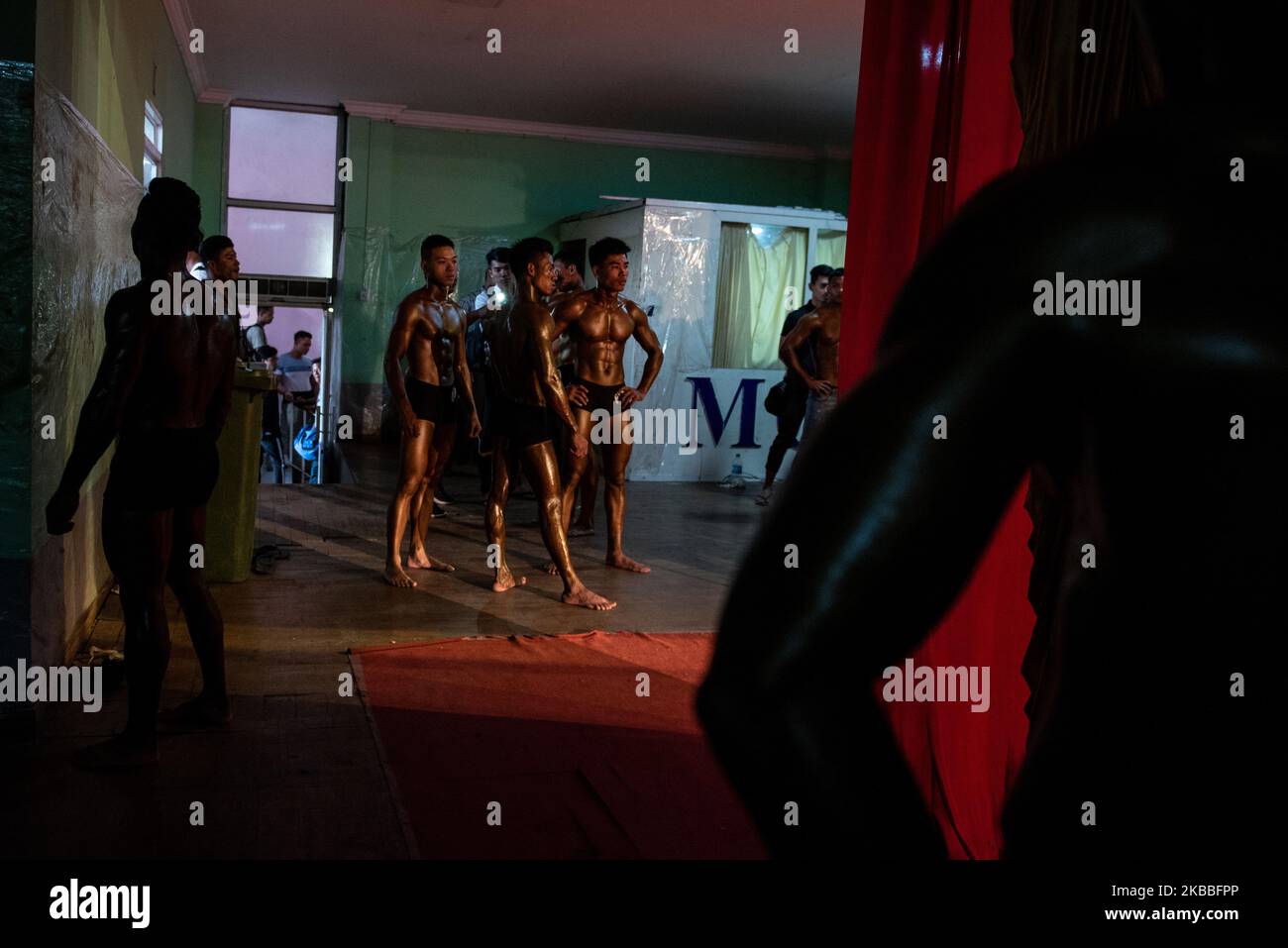 Male bodybuilding athletes prepare backstage during the 46th State and ...