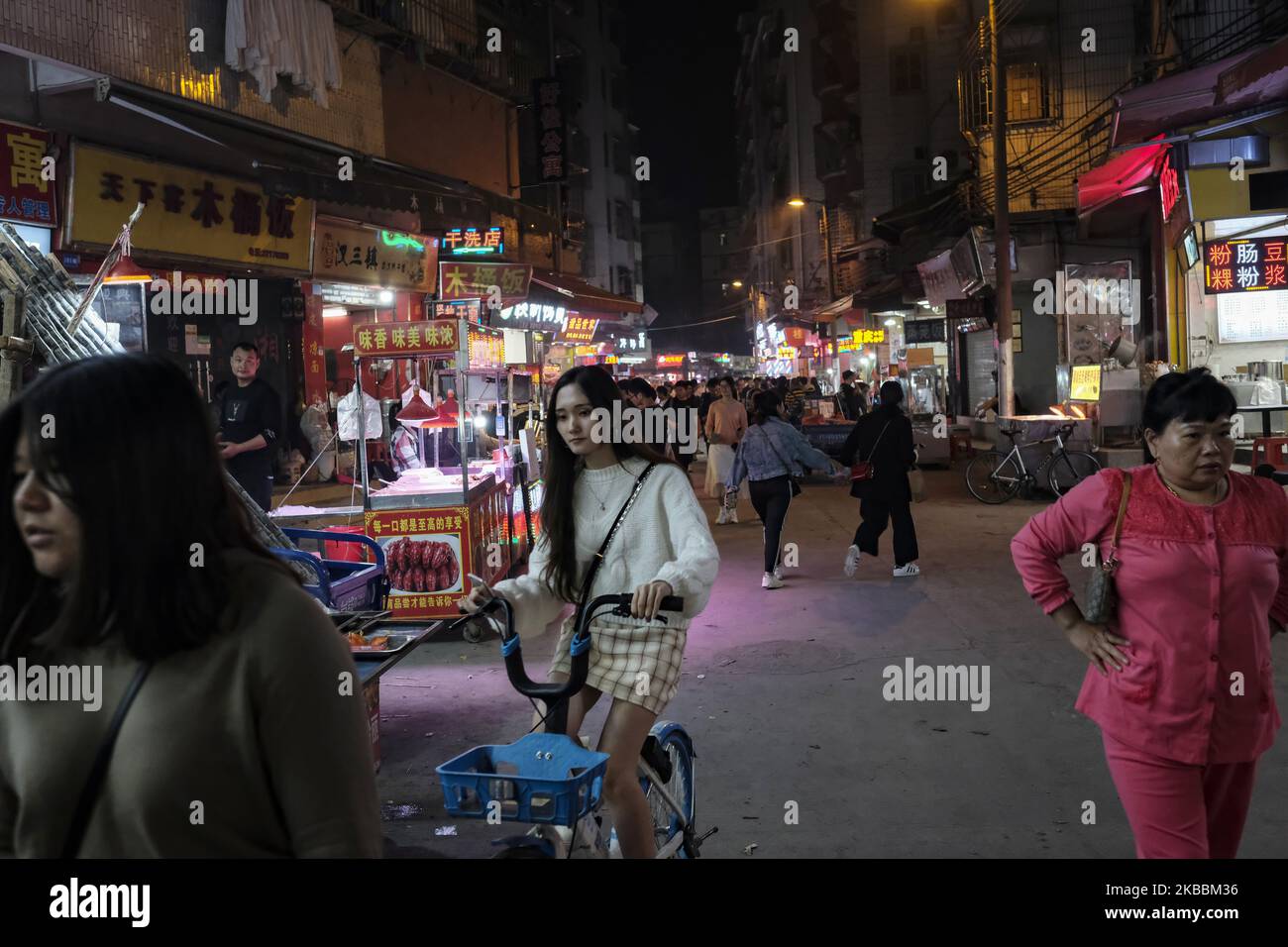Chinese walk on a busy street at night in the city of Guangzhou in ...