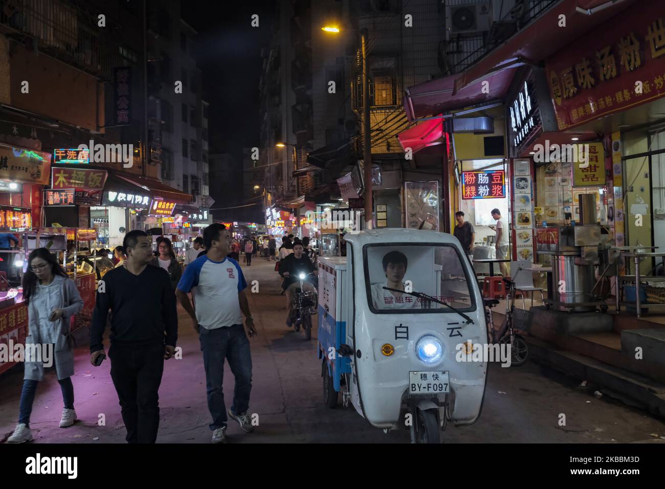 Chinese walk on a busy street at night in the city of Guangzhou in ...